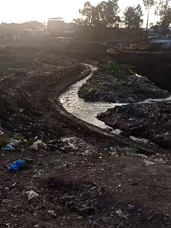 polluted river flowing through a landscape covered in garbage in ...